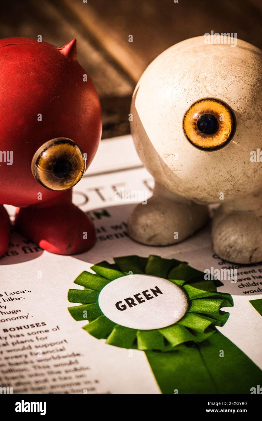 Two small red round toys with one eye on a book Stock Photo - Alamy
