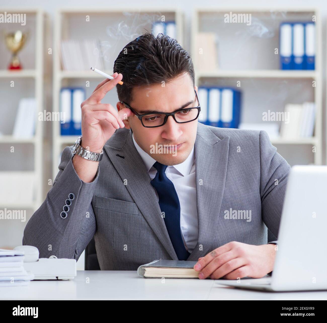 The businessman smoking in office at work Stock Photo - Alamy