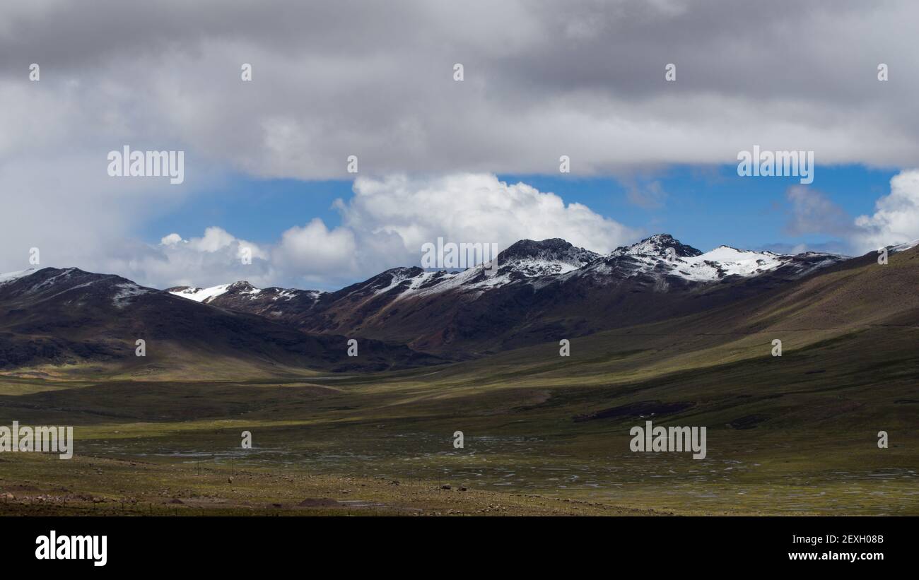 Snowy Andes Mountain range peak grassy hills beside in cusco Peru Stock ...