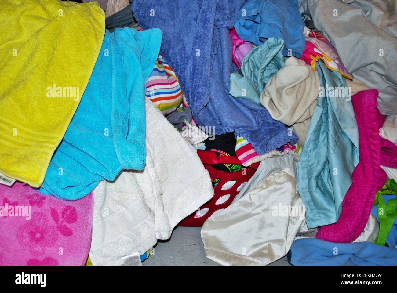 Pile of dirty towels that need to be washed in a basement laundry room ...