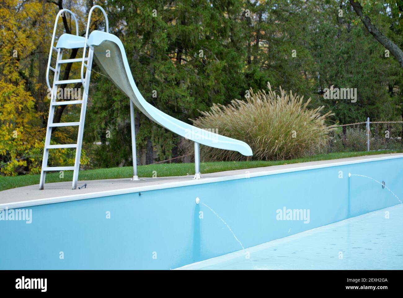 backyard swimming pool with pool slide emptied out shutting down for ...