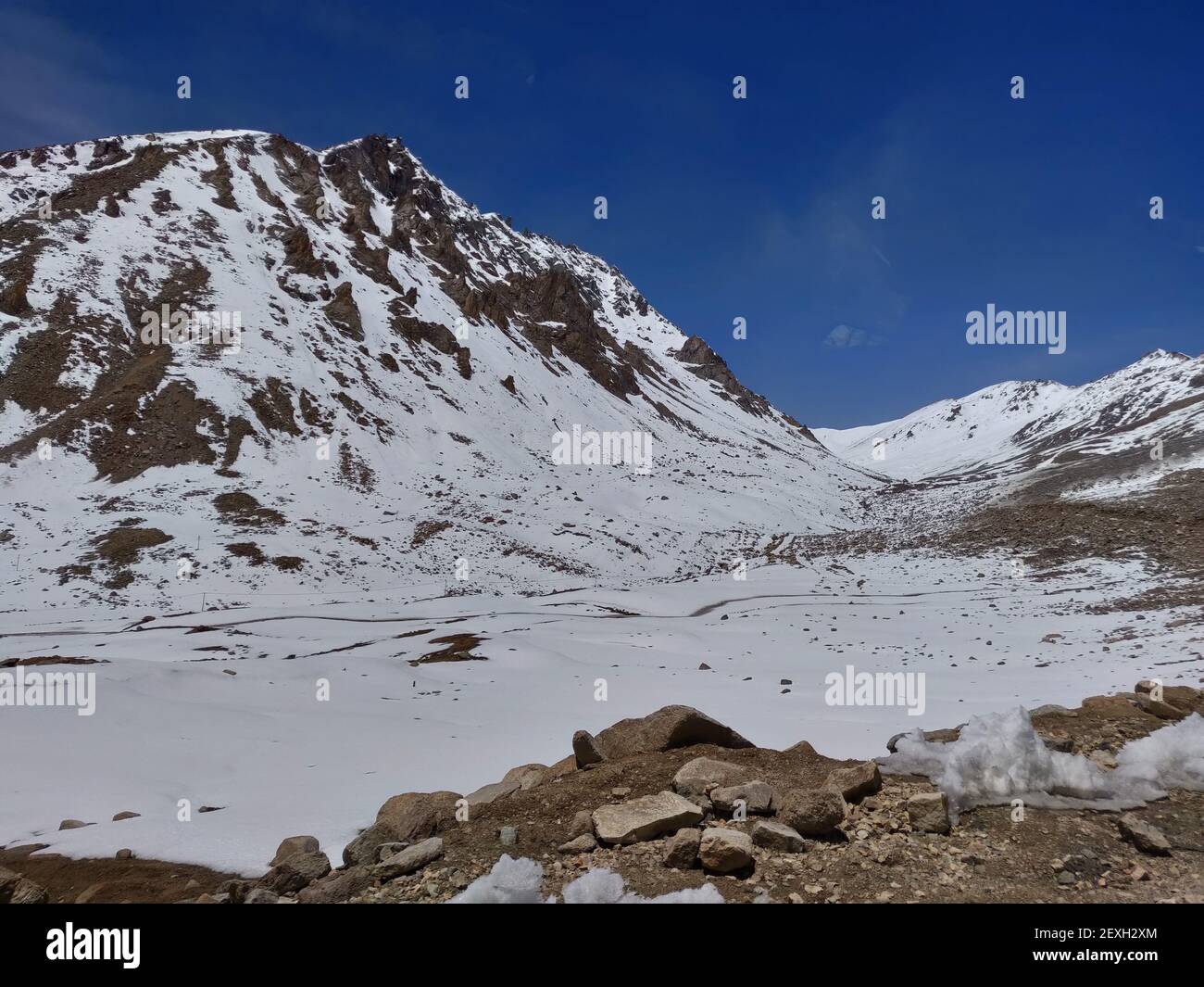 A chilling view of a mountainous landscape under a deep blue sky ...