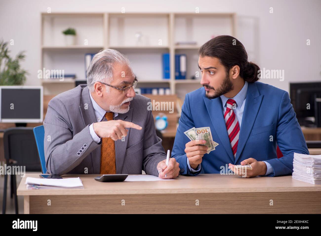Two employees in remuneration concept Stock Photo - Alamy