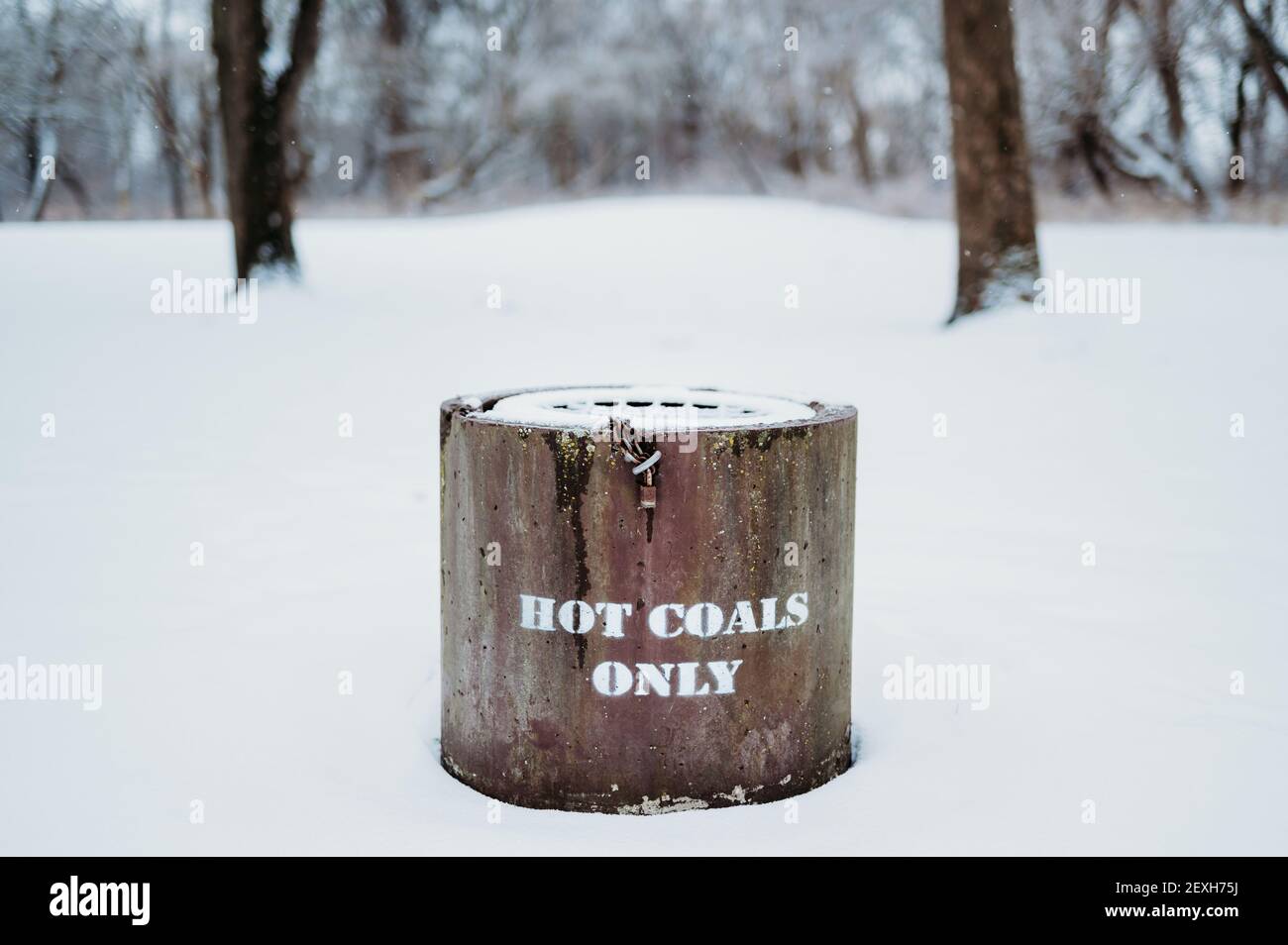 a hot coal bin with a white "hot coals only" text in a snowy field ...