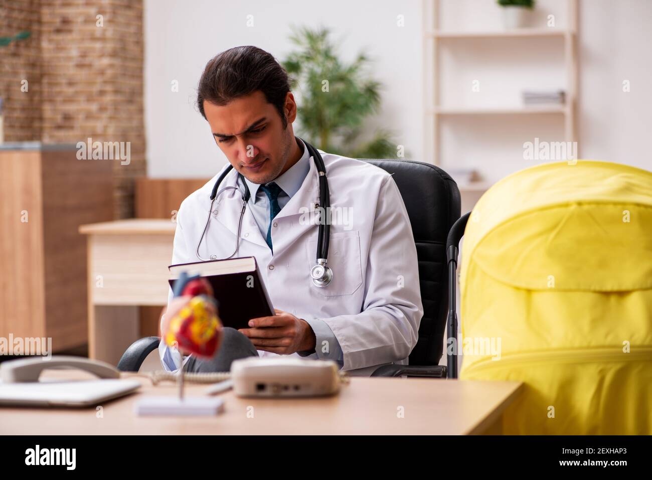 Young male doctor looking after new born at the hospital Stock Photo ...