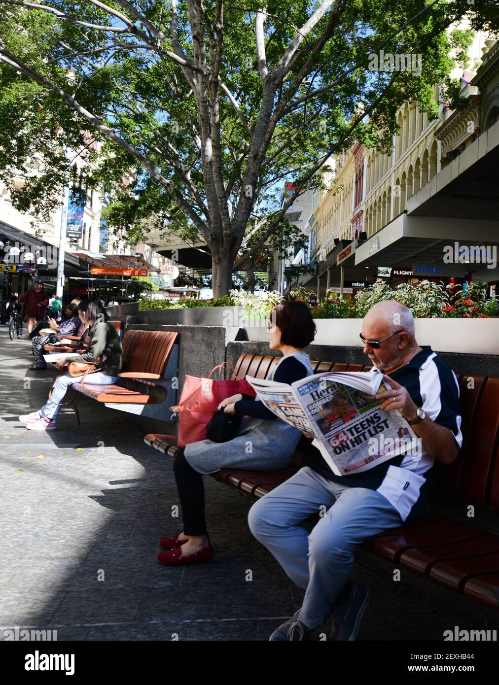 An Australian man reading the newspaper on Albert street in Brisbane ...