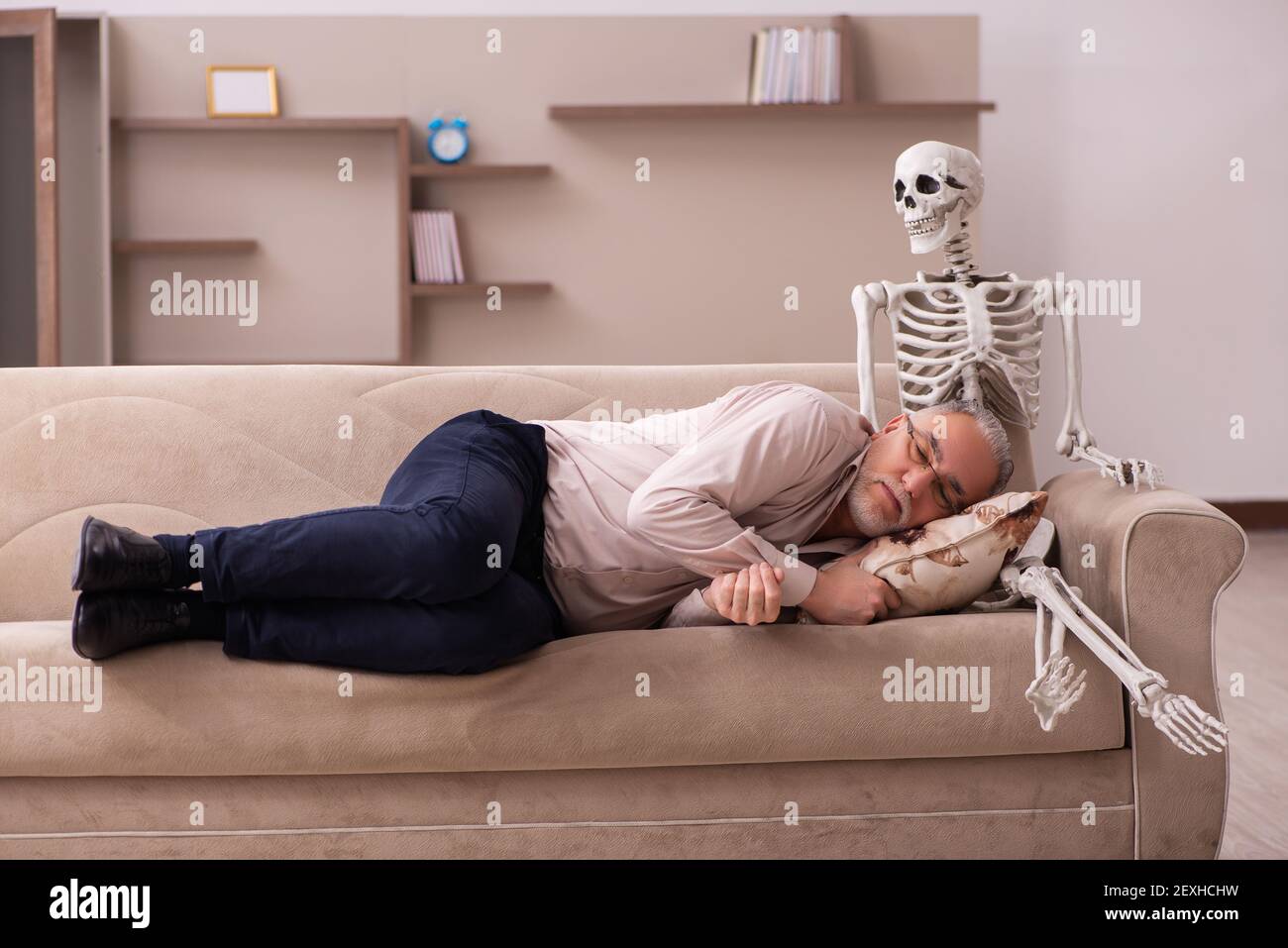 Old man sitting on the sofa with the female skeleton in undying love ...