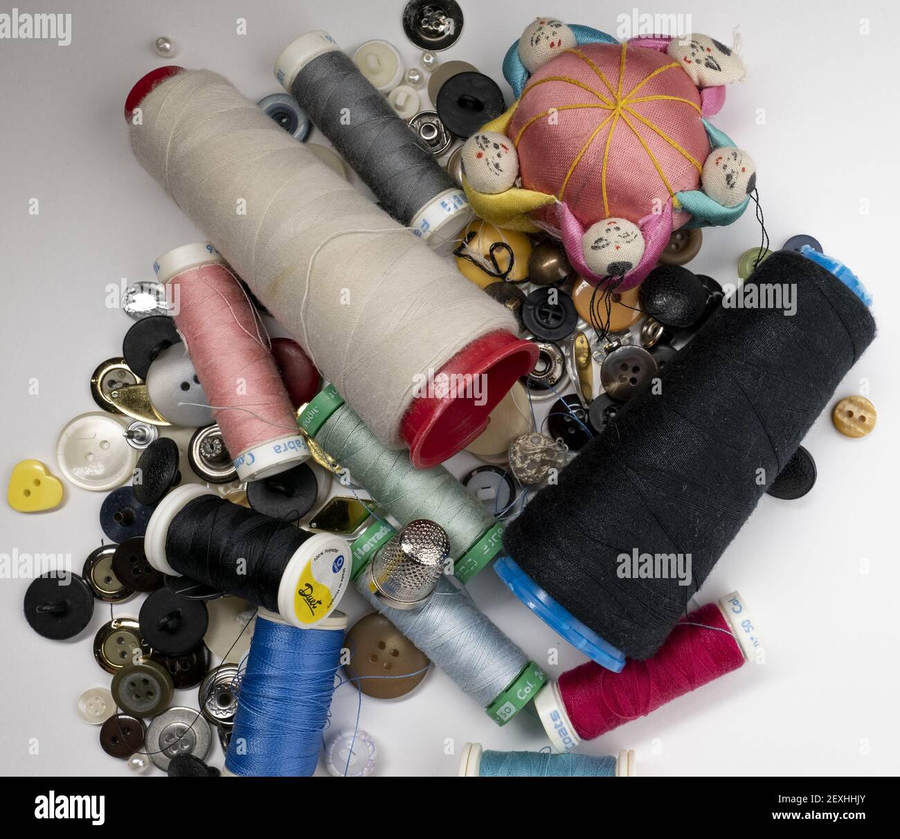 A closeup shot of buttons of various sizes and colors and rolls of ...