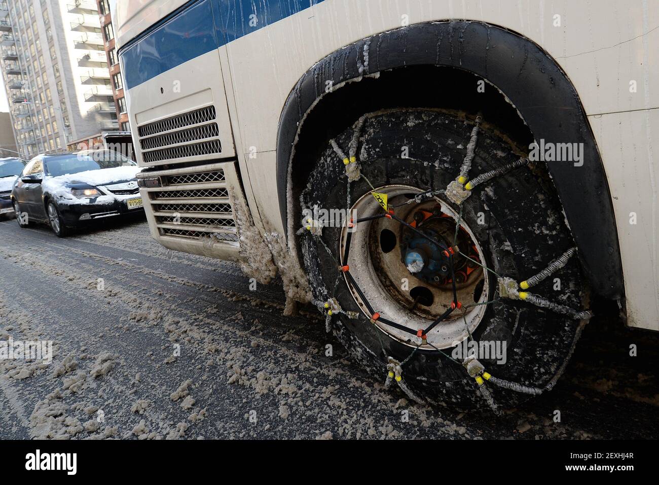 A New York City Transit bus is outfitted with tire snow chains after a ...
