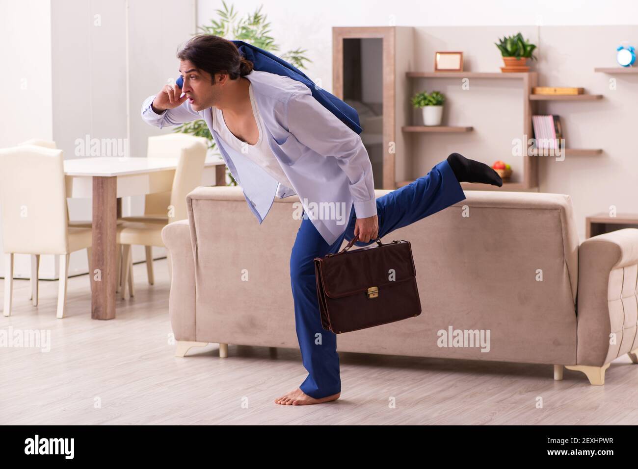 Young employee getting up late at home Stock Photo - Alamy
