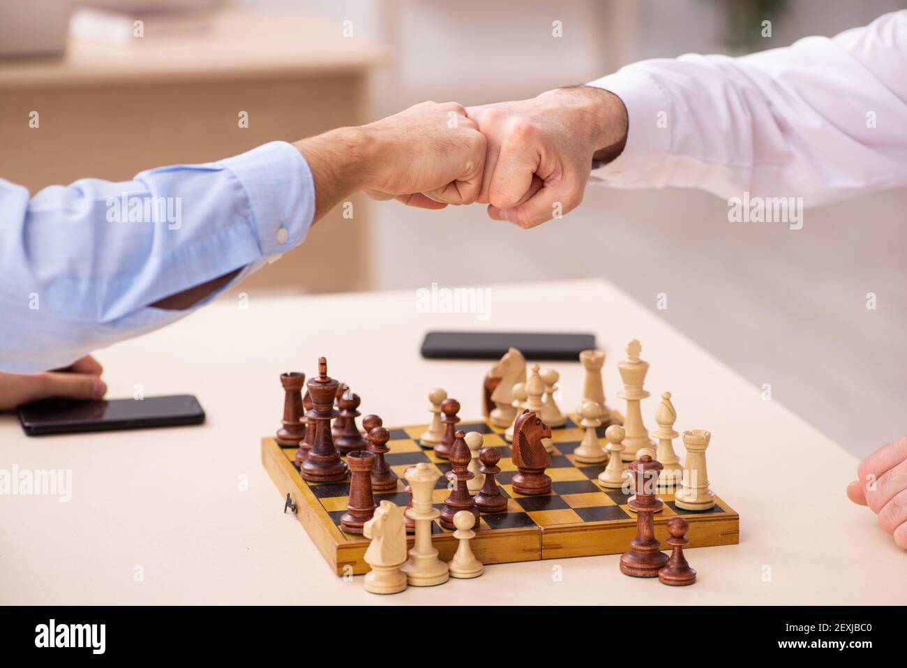 Two male employees playing chess at workplace Stock Photo - Alamy