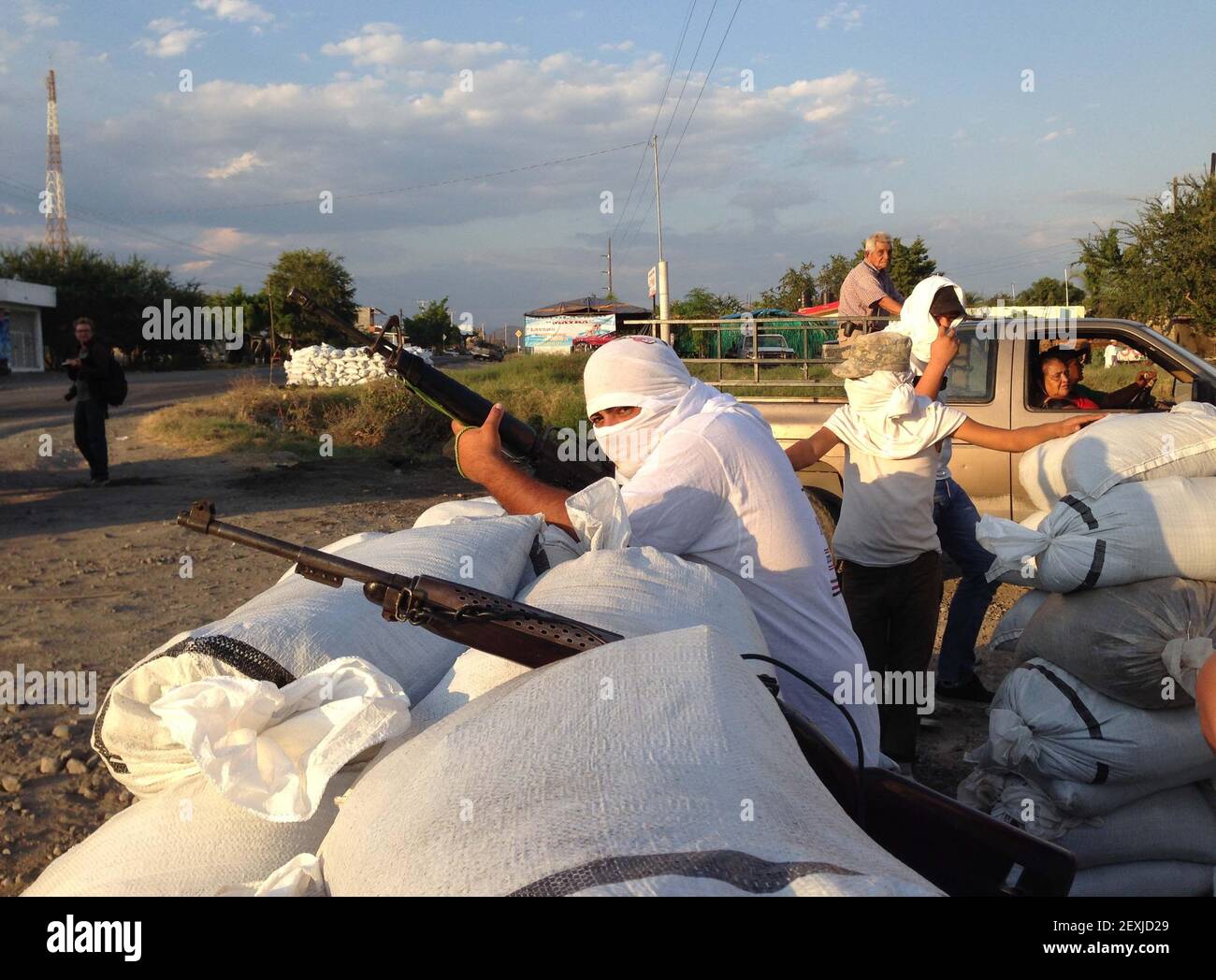 Armed self-defense units guard an entrance into the town of Nueva ...