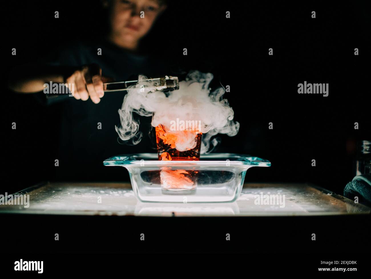 Young boy plays and experiments with dry ice over a light table while ...
