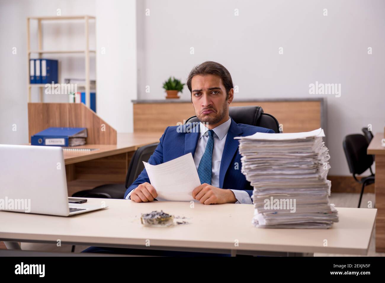 Young male employee reading contract at workplace Stock Photo - Alamy