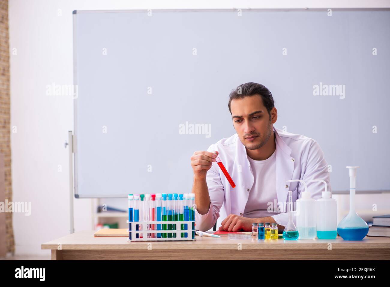 Young chemistry teacher in the classroom Stock Photo - Alamy