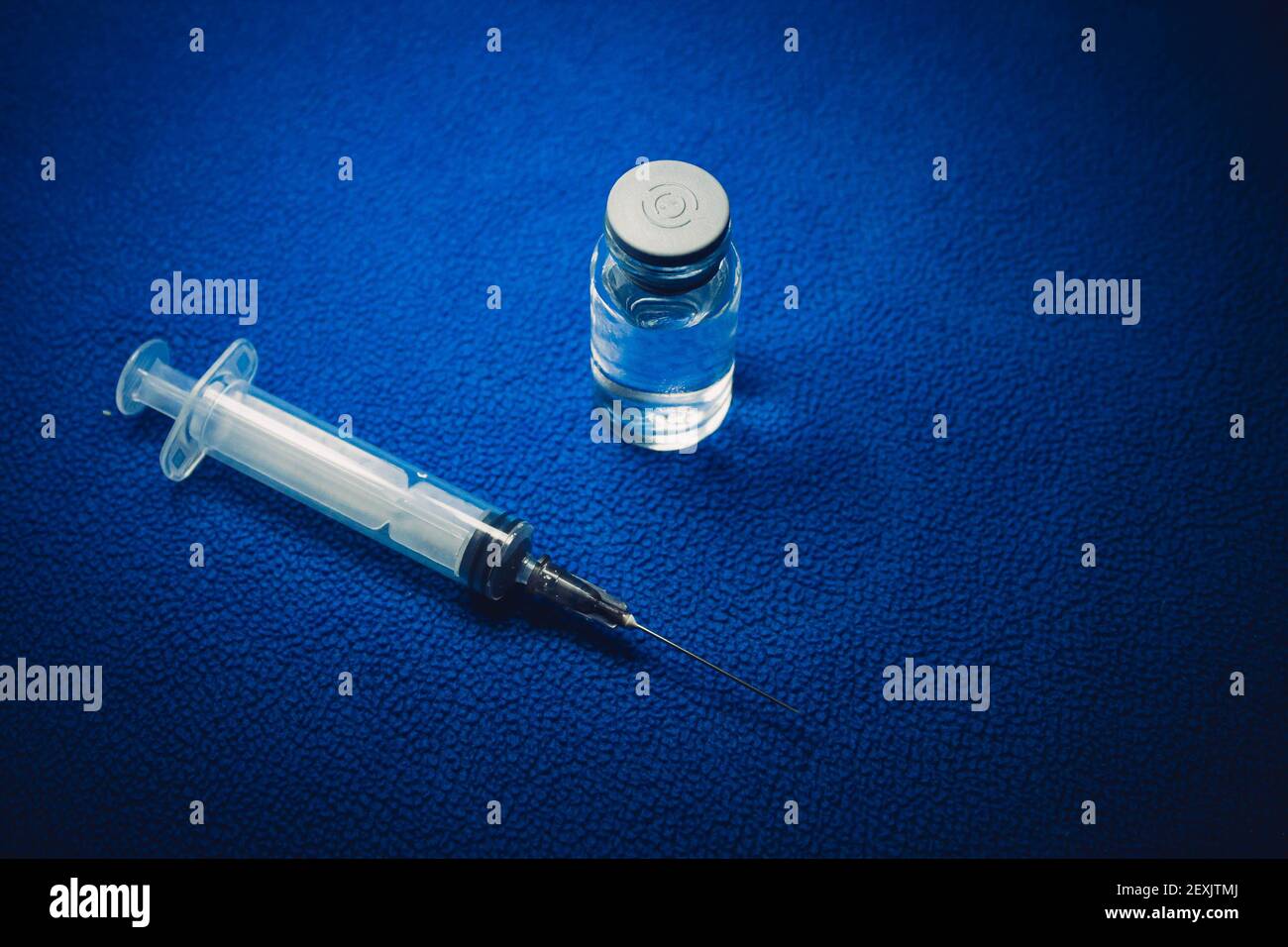 Vaccine in vitro. Medicine in a flask on a blue background. Antibiotic ...