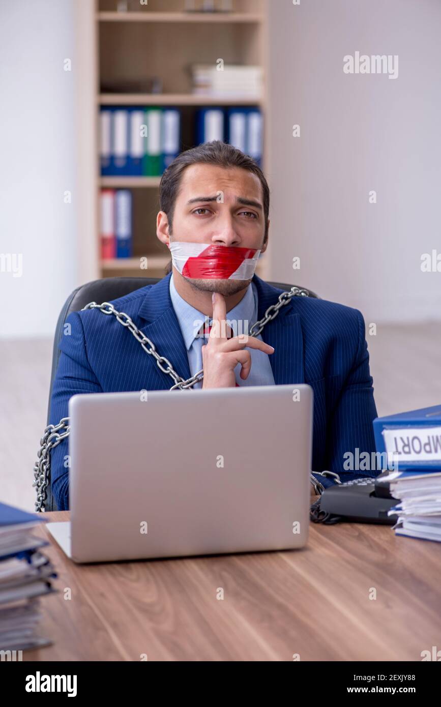 Chained employee unhappy with excessive work in the office Stock Photo ...