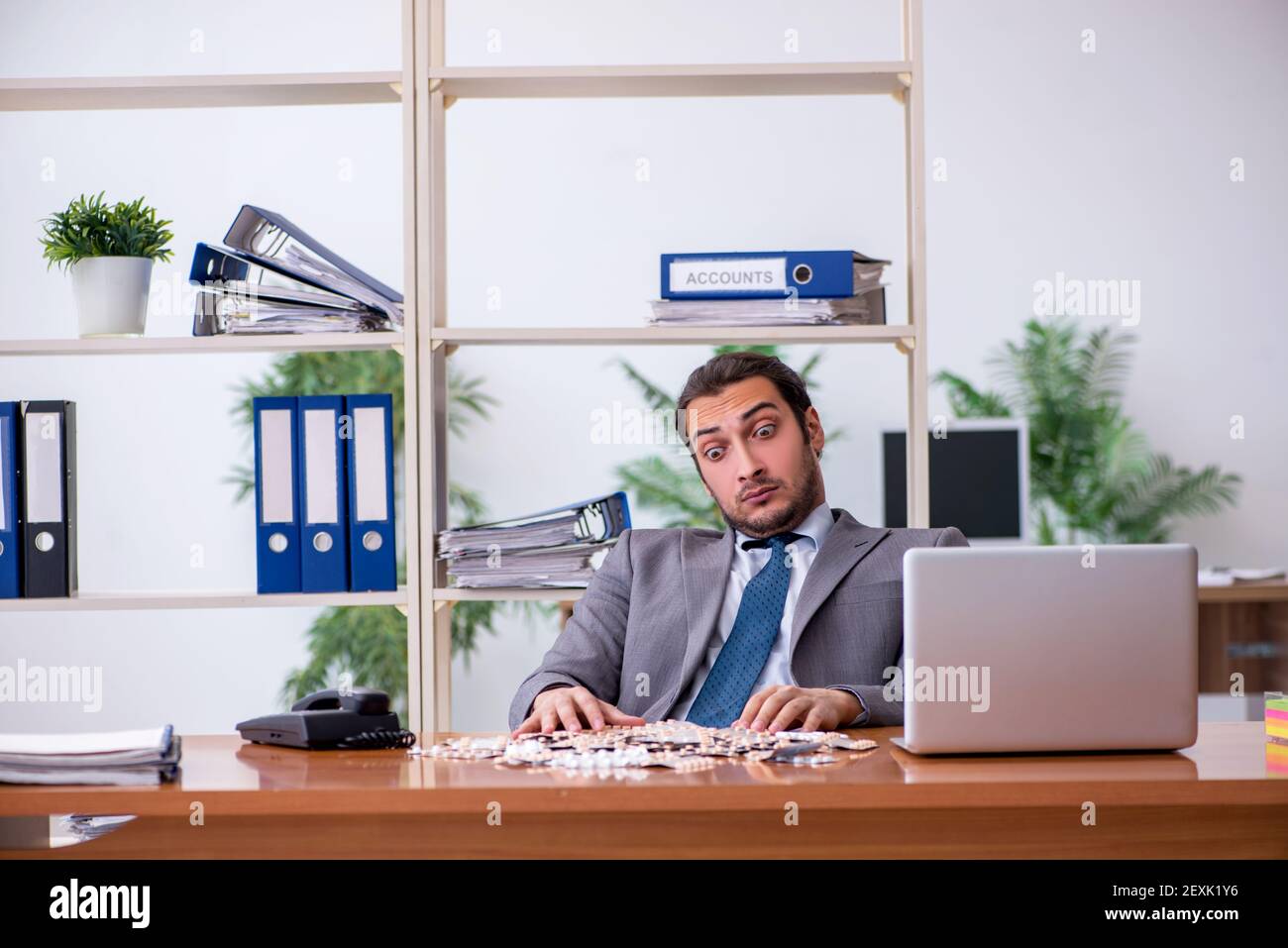 Male sick employee suffering at workplace Stock Photo - Alamy