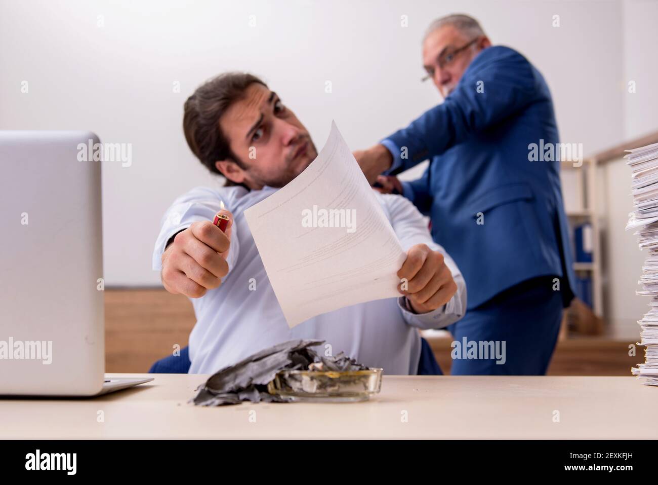 Male employee and his old boss burning papers at workplace Stock Photo ...