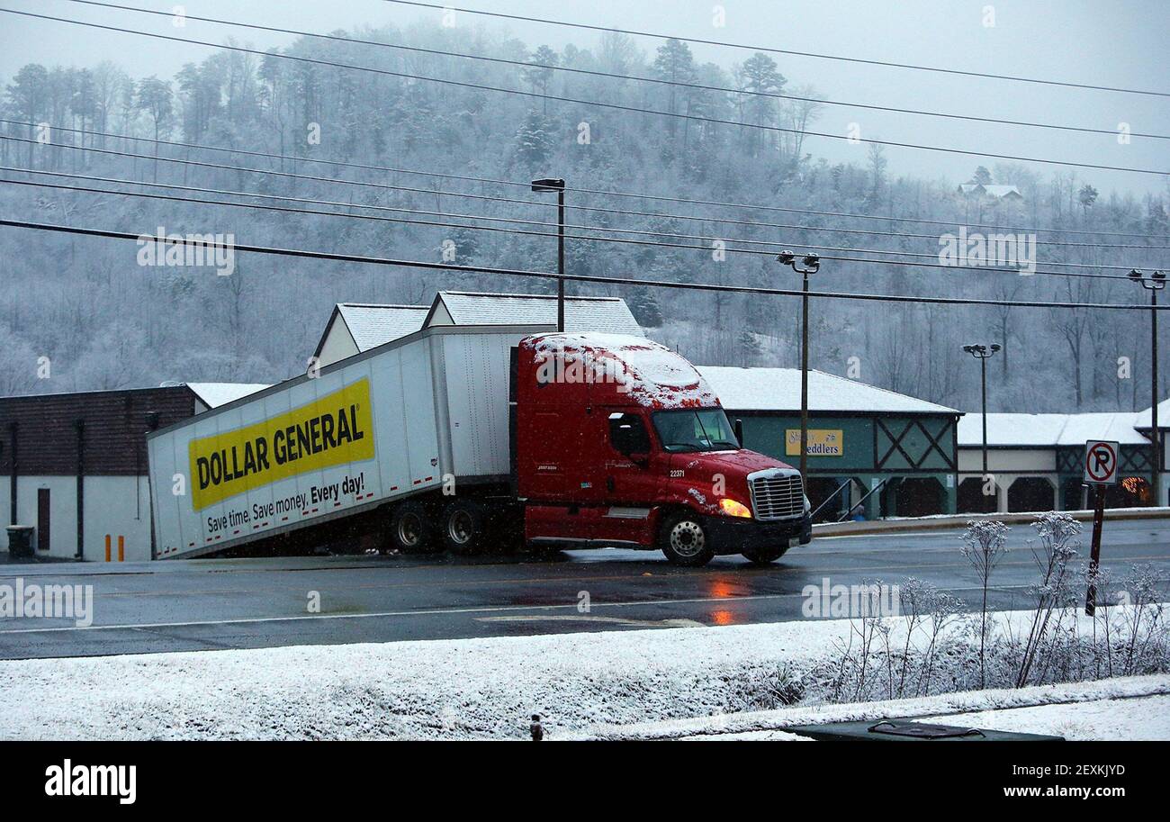 A Dollar General truck makes its way up a hill from a parking lot while ...