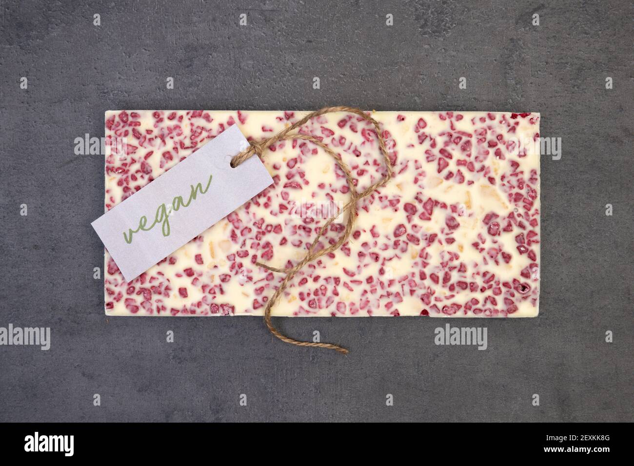 sweet bar of chocolate lies on a gray stone background with a label ...