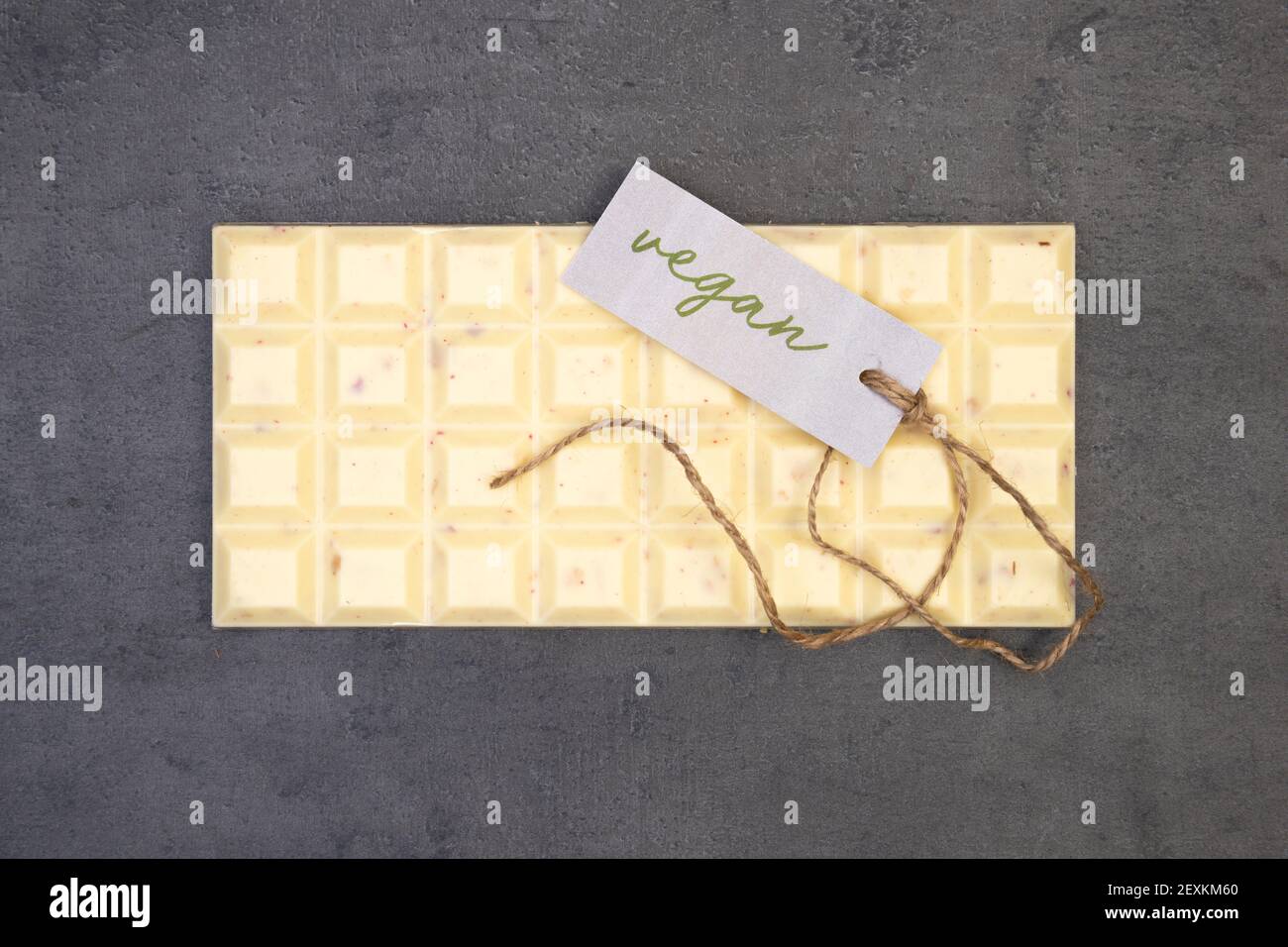 sweet bar of chocolate lies on a gray stone background with a label ...
