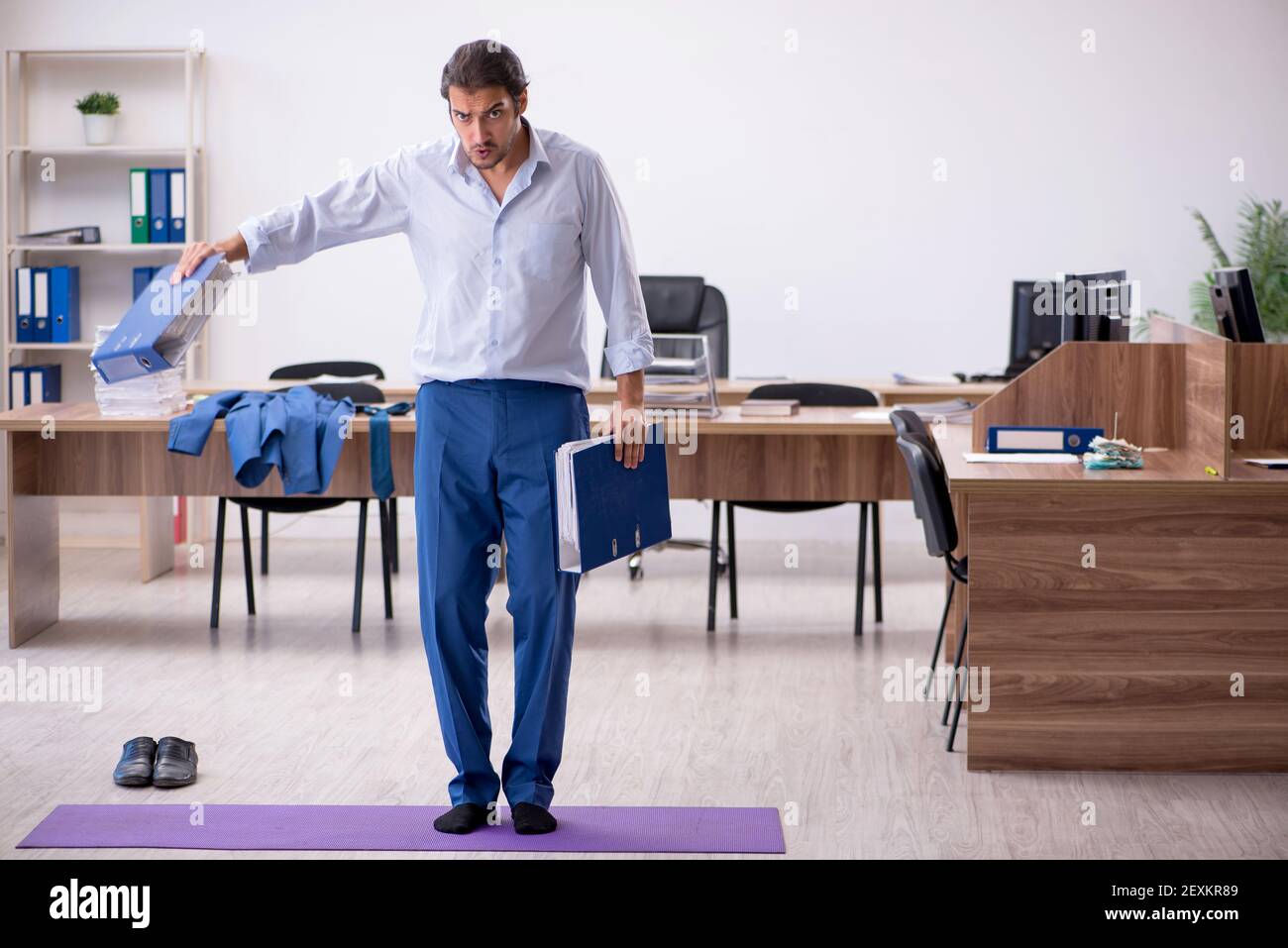 Young employee doing sport exercises during break Stock Photo - Alamy