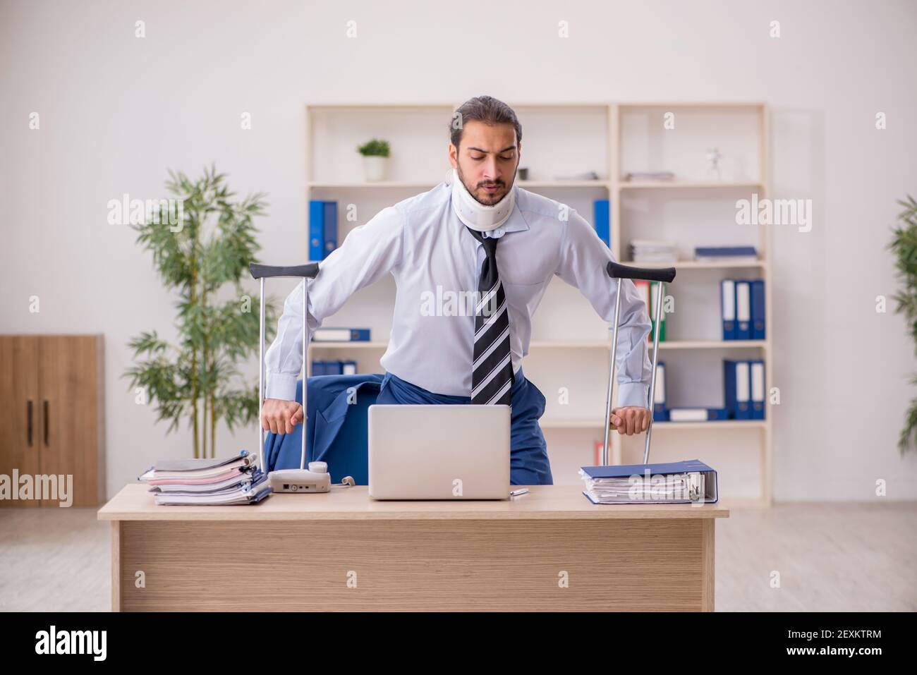 Young man after accident working in the office Stock Photo - Alamy