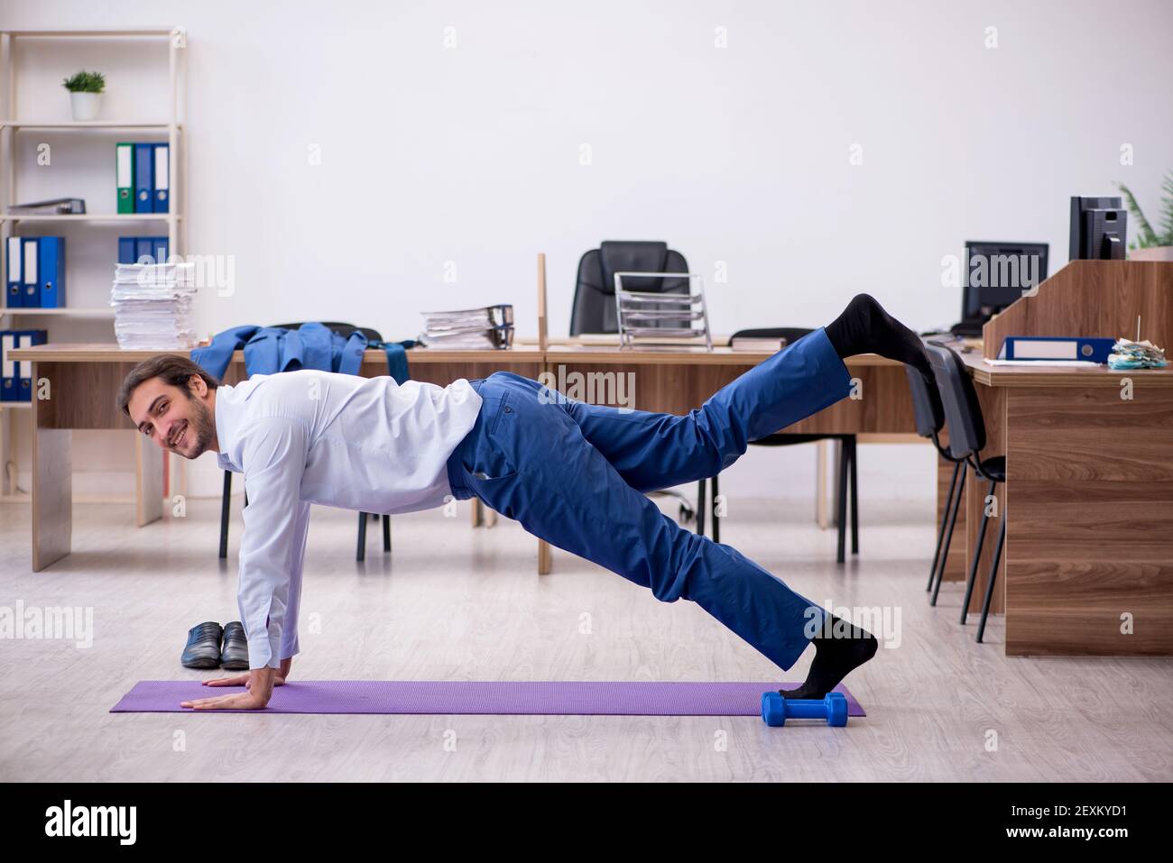 Young employee doing sport exercises during break Stock Photo - Alamy