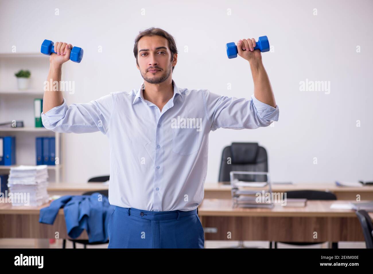 Young employee doing sport exercises during break Stock Photo - Alamy