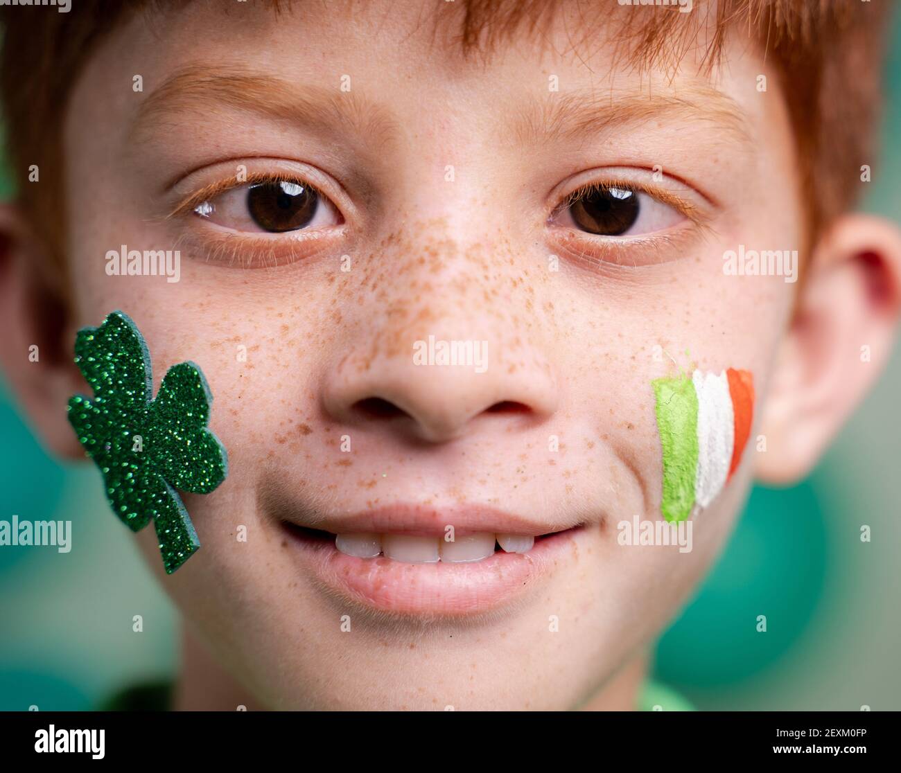Close up of smiling kid with saint patricks day tricolour Irish flag ...