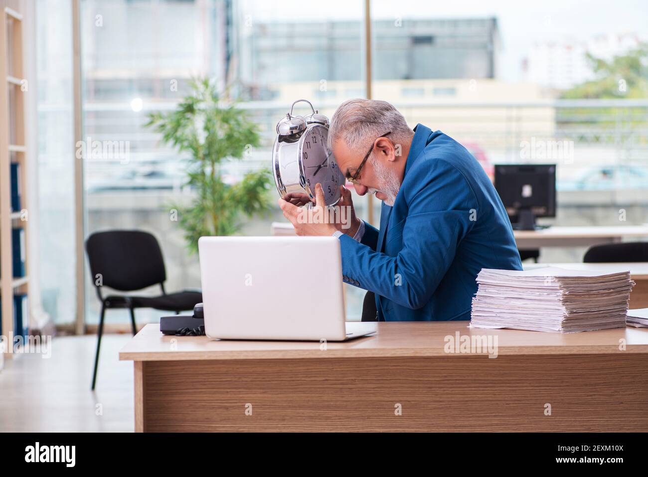 Old boss employee in time management concept Stock Photo - Alamy