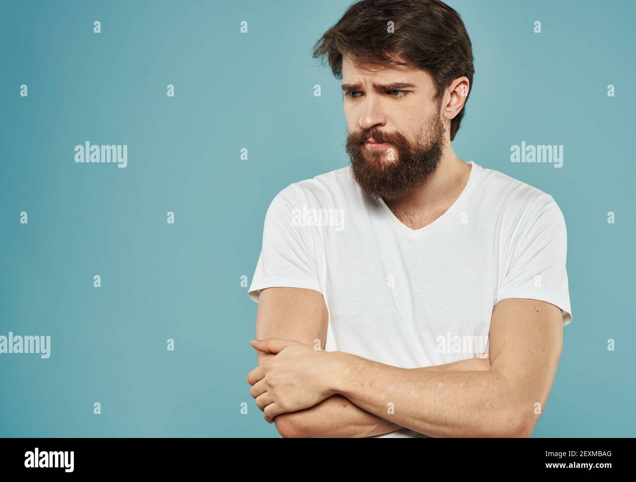 Upset man on a blue background crossed his arms on his chest emotions ...