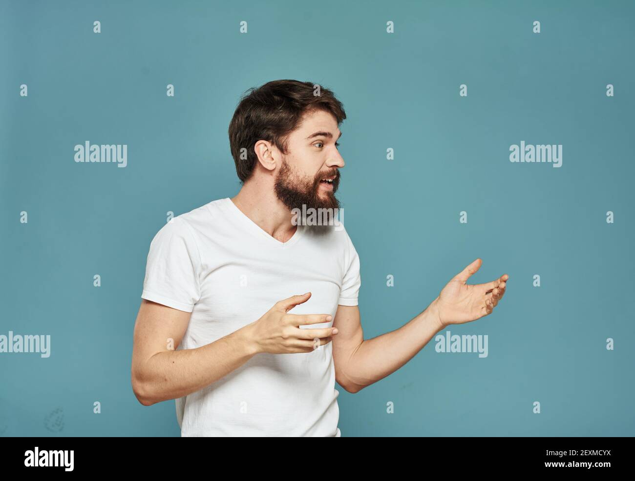 Energetic man gesturing with his hands on a blue background joy emotion ...