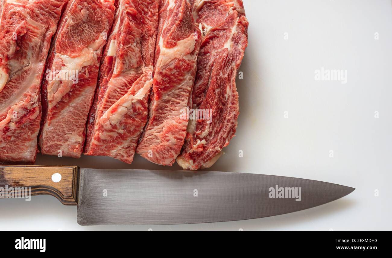 A top view of raw beef cuts and knife isolated on white background ...