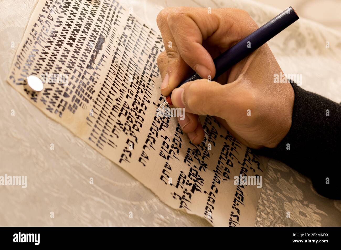 A writer's hand practices decorating letters from a Torah scroll ...