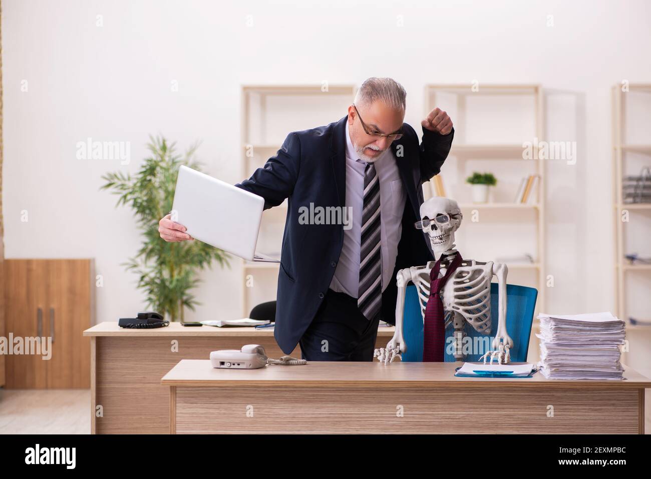 Dead employee working in the office in funny concept Stock Photo - Alamy