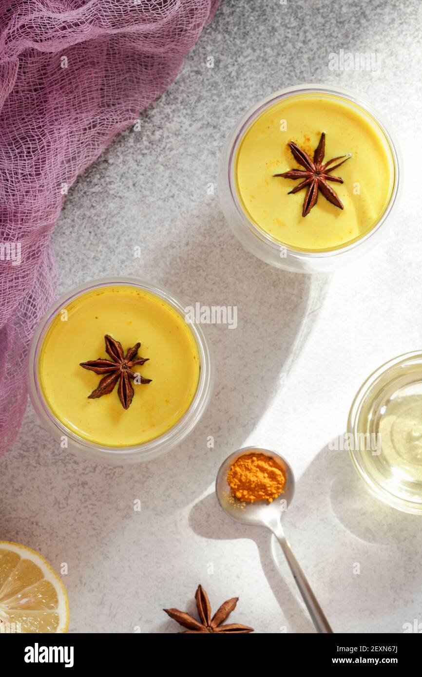 Turmeric, golden milk with lemon, spoon with turmeric powder, honey and ...