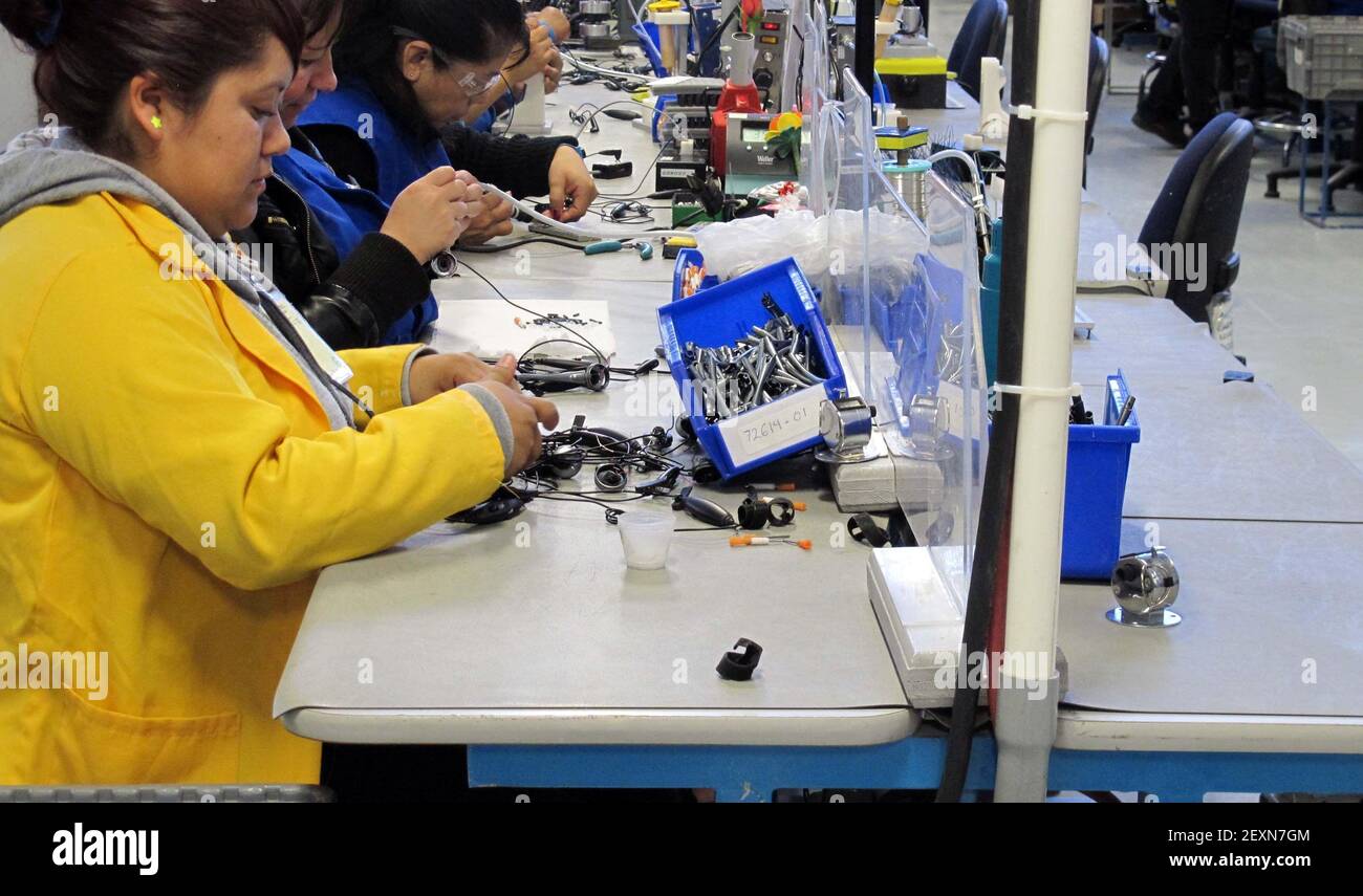 A worker assembles a headset at the Plantronics factory in Tijuana ...