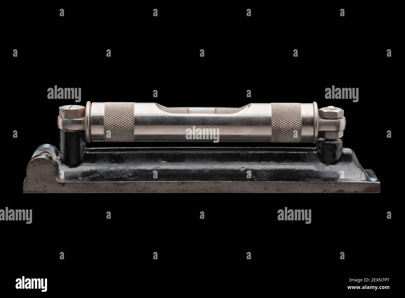Vintage engineer's spirit level viewed side-on against a black ...