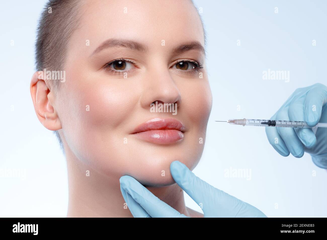 Beautiful woman with short hair gets a beauty injection in her face ...