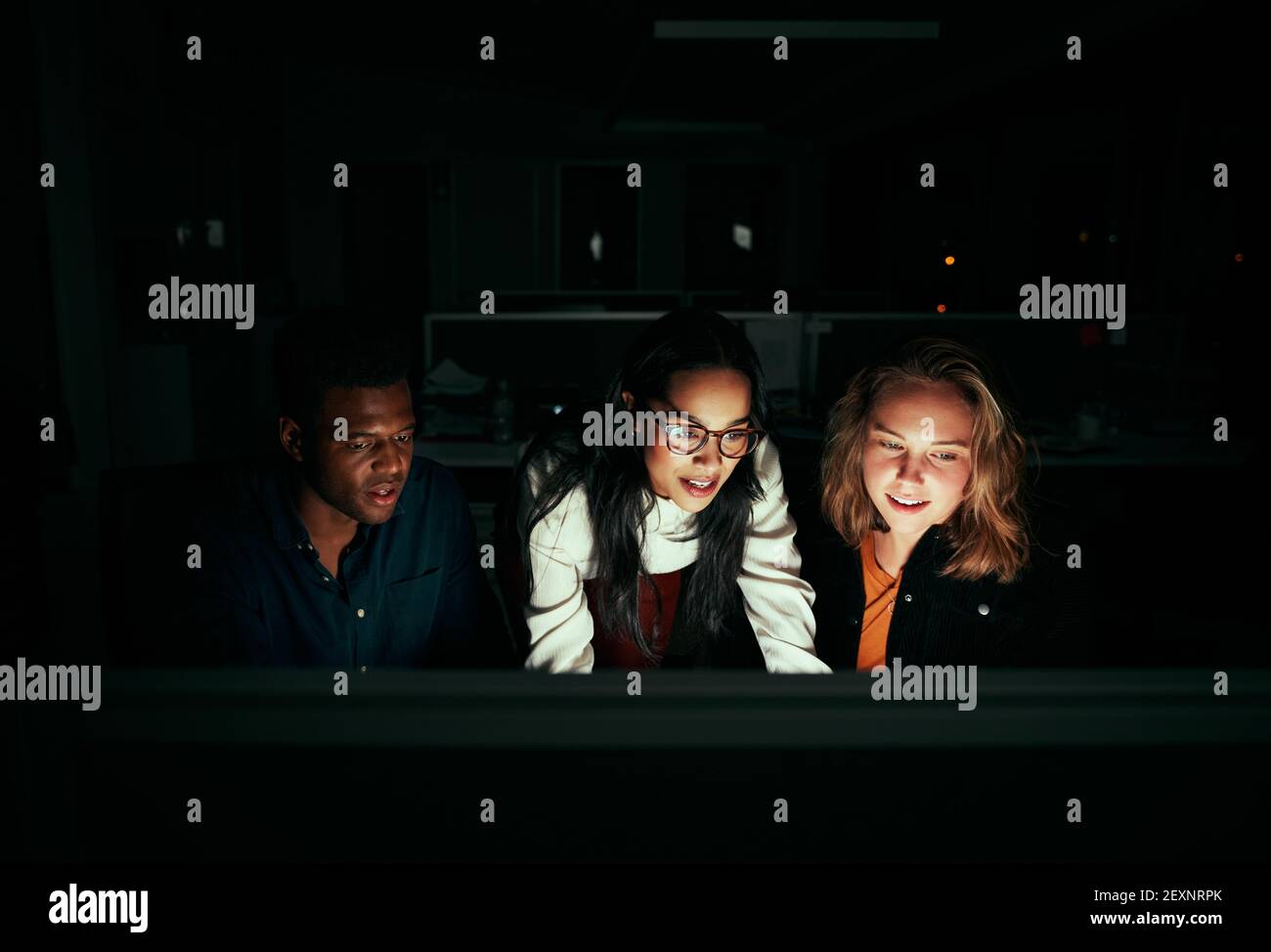 Group of diverse business team working together at their desk in dark ...
