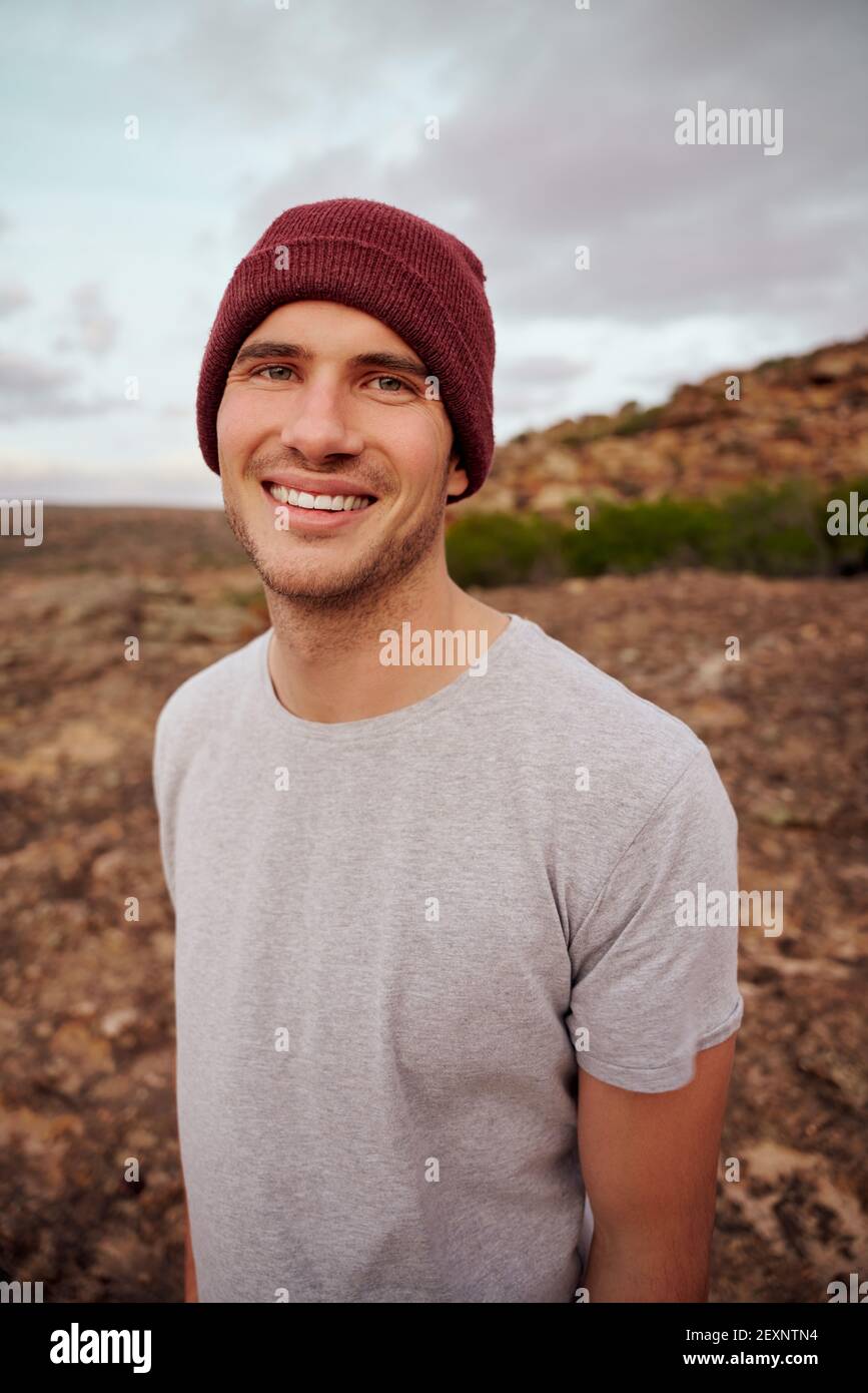Portrait of smiling male hiker looking at camera standing on mountain ...