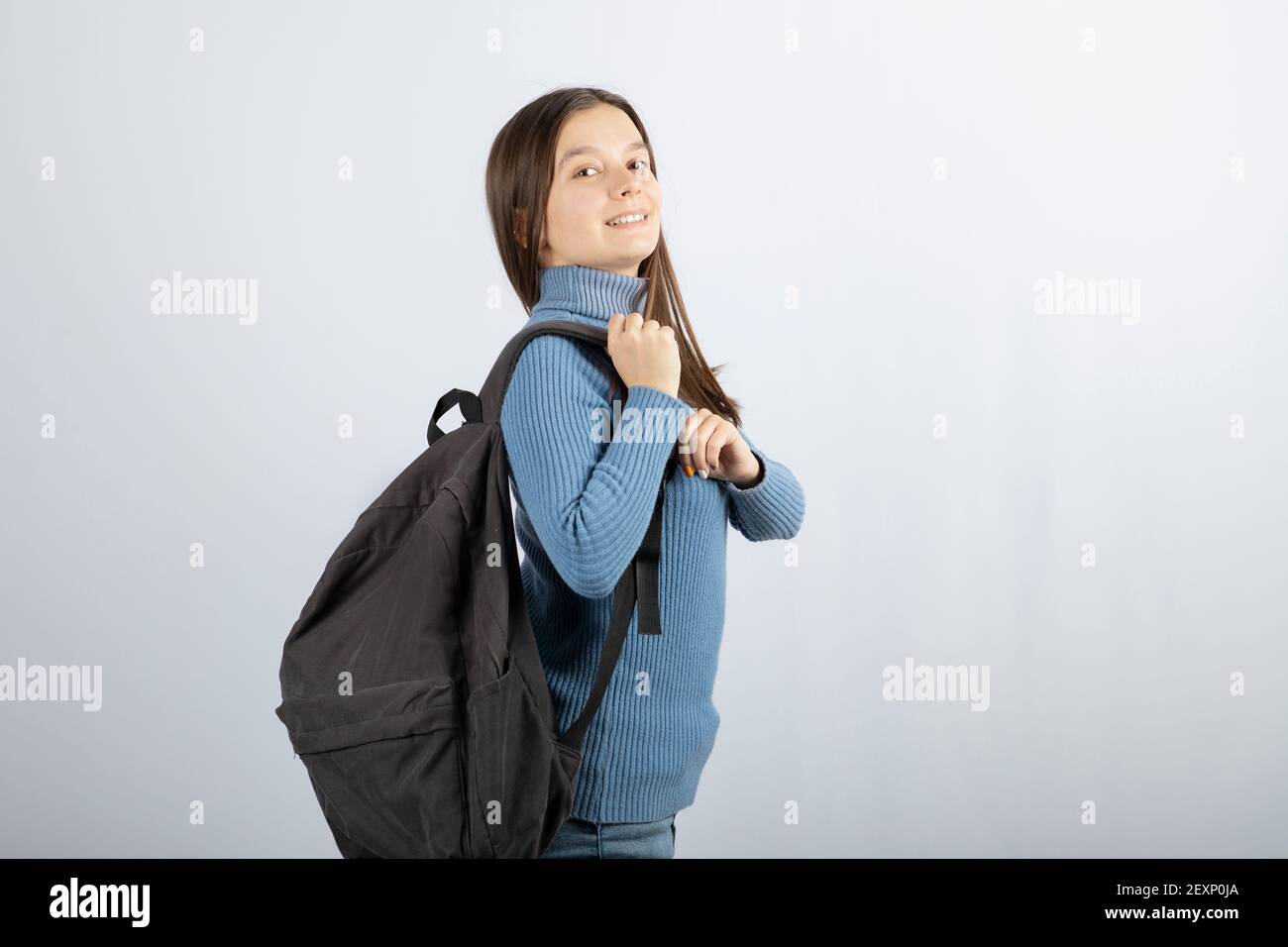 Portrait photo of a young girl model standing with backpack and posing ...