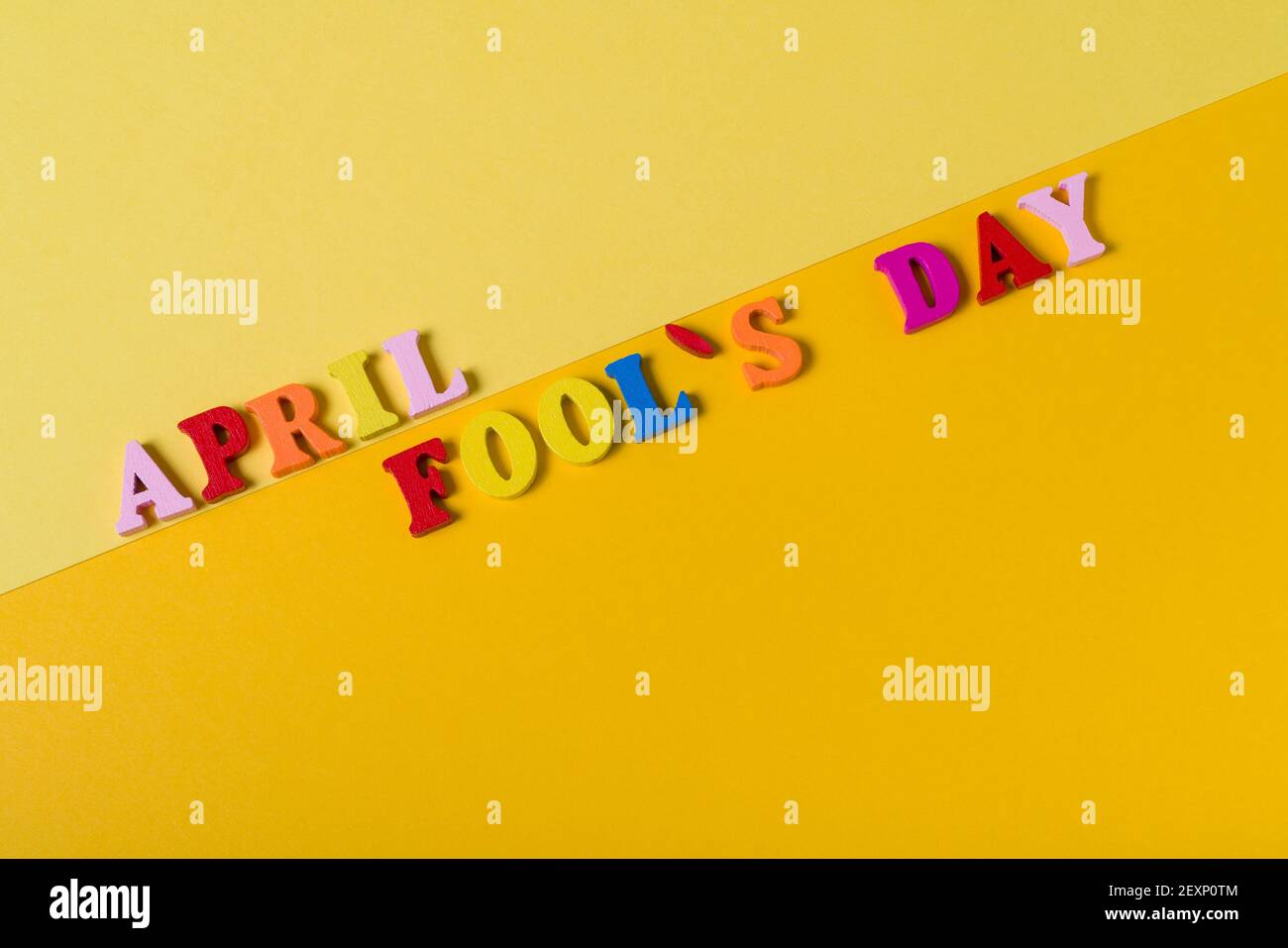Wooden letters the first of April on a yellow background. The concept ...