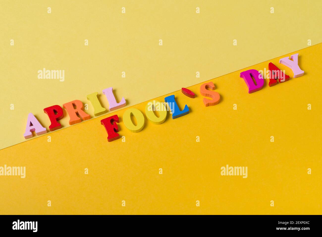 Wooden letters the first of April on a yellow background. The concept ...