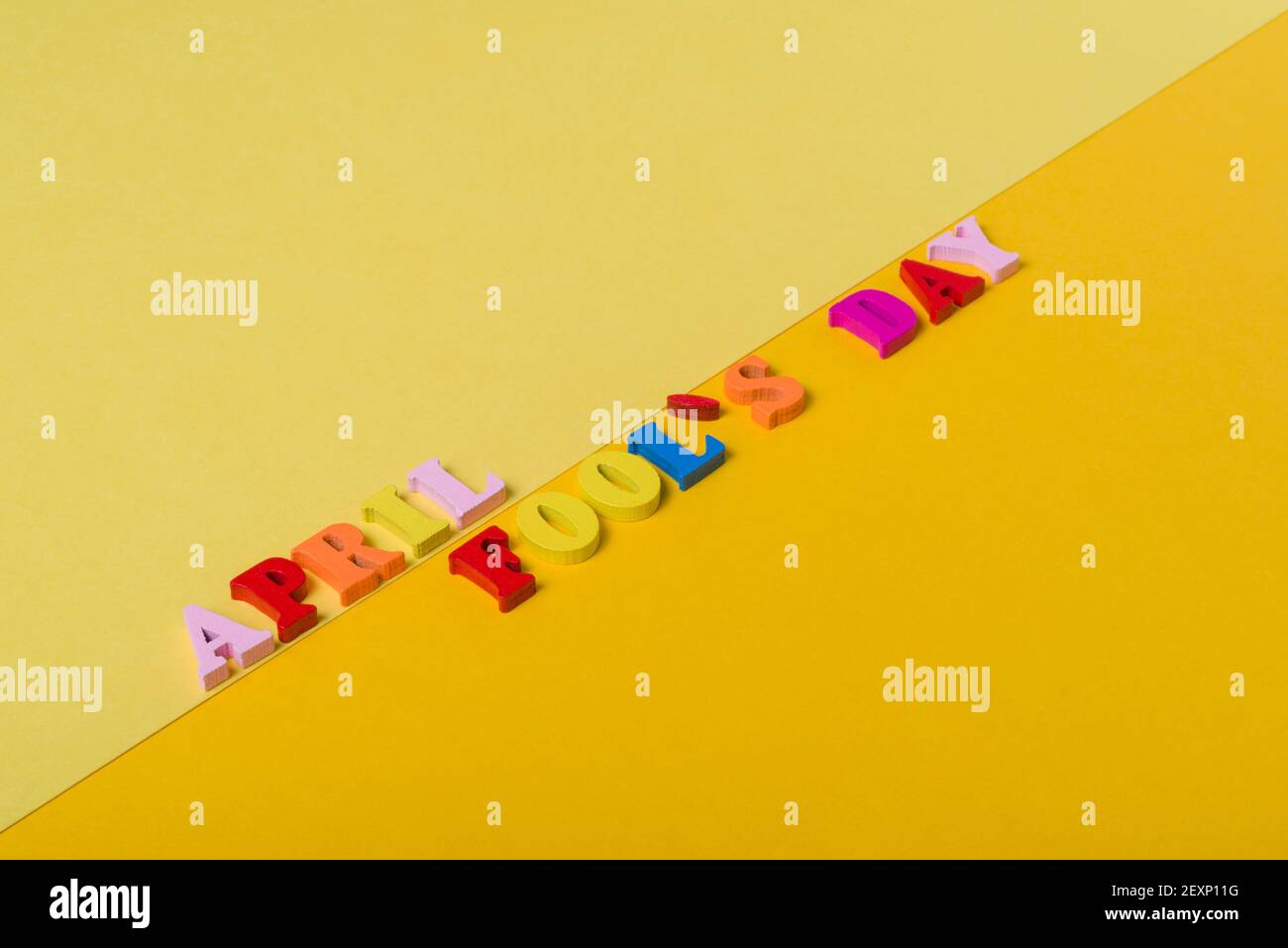 Wooden letters the first of April on a yellow background. The concept ...