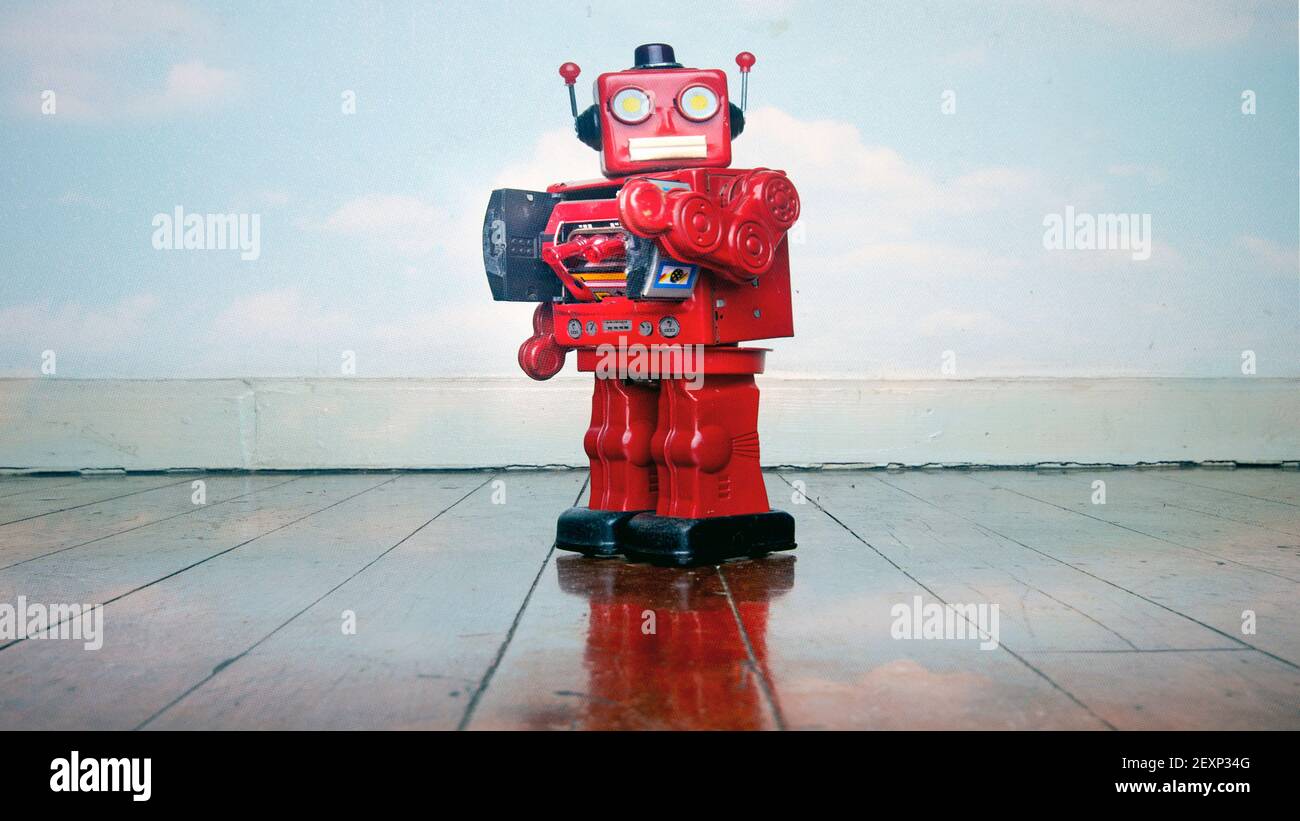 retro robot toy on a old wooden floor with sky and clouds background ...