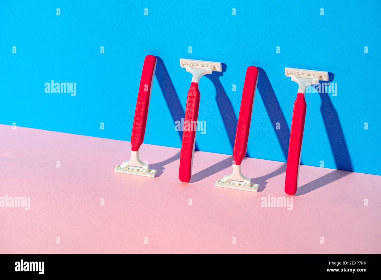 Disposable razor on blue and pink background Stock Photo - Alamy