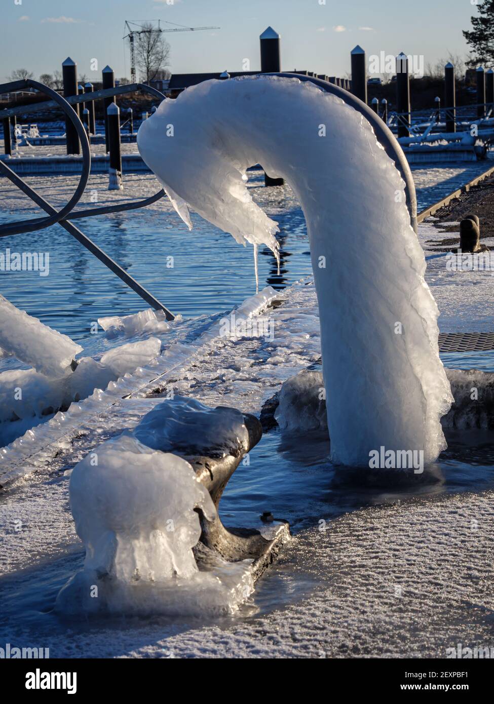 A vertical shot of curved metal pole covered with ice Stock Photo - Alamy